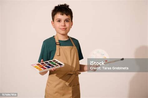 백인 잘생긴 재능 있는 십대 소년이 수채화와 붓으로 팔레트를 들고 카메라를 향해 미소를 짓고 있다 미술 수업 개념에 대한 스톡 사진 및 기타 이미지 Istock