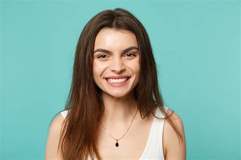 스튜디오에서 파란색 청록색 벽 배경에 고립 된 빛 캐주얼 옷을 찾고 쾌활 한 젊은 여자 웃는의 초상화 사람들은 진심으로 감정 라이프 스타일 개념입니다 복사 공간을 모의