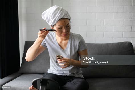 매력적인 젊은 여자는 얼굴에 목욕 수건과 크림 마스크로 싸여 가꿔주기에 대한 스톡 사진 및 기타 이미지 가꿔주기 가정 생활