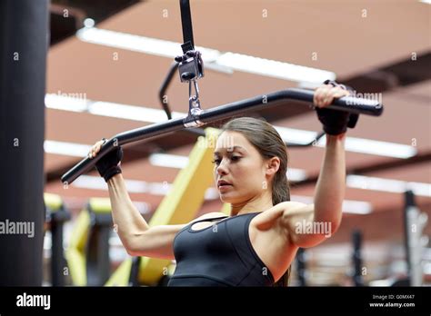 Woman Flexing Arm Muscles On Cable Machine In Gym Stock Photo Alamy