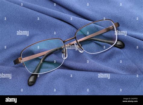 Stylish Eyesight Glasses And Blue Glass Cleaning Cloth Background Stock