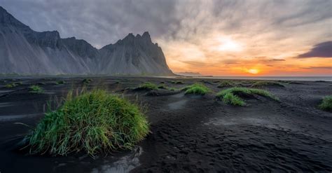 Vestrahorn 검은 모래 해변 경치 경치가 좋은 고요한 광야 구름 낀 하늘 깨끗한 대기의 모험 바다 바위로 된 바이킹 북유럽 북유럽 인 산
