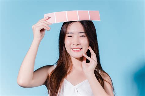 매력적인 아시아 뷰티 우먼은 파란색 배경에 자외선 차단 Uv 또는 자외선 차단제로 선크림과 컬러 스케일을 들고 있습니다 18