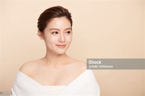 베이지 색 배경에 깨끗한 신선한 피부를 가진 아름다운 젊은 아시아 여성 얼굴 관리 얼굴 치료 화장품 아름다움과 스파 아시아 여성