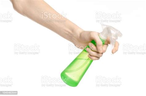 청소기 테마 고 집 청소 스튜디오에서 흰색 배경에 고립 된 청소에 대 한 녹색 스프레이 병을 들고 남자의 손 가사 집안일에 대한