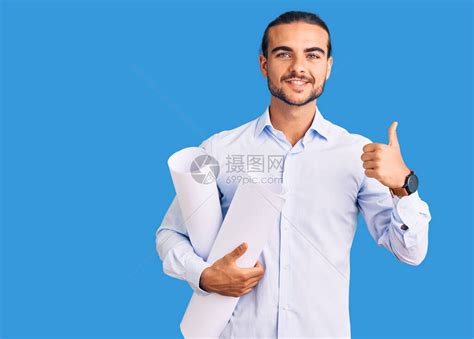英俊的年轻帅哥拿着纸蓝图高清图片下载 正版图片504249059 摄图网