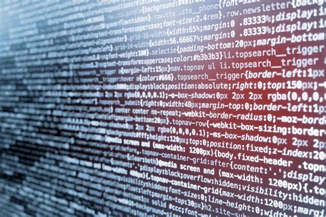 css programming code on screen in blue tones and red light leak stock