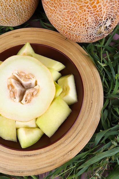 Premium Photo Melon On Brown Plate On Bamboo Plate On Grass Background