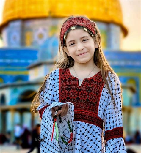 فلسطين أون لايـن طفلة فلسطينية ترتدي ثوبًا تقليديًا تلتقط صورة في