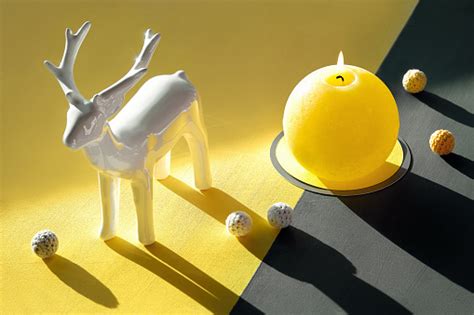 2021년 의 색상인 옐로우와 얼티밋 그레이를 일루미네이션 세라믹 사슴 불타는 촛불 면화 꽃과 갈라진 노란색 회색 배경에 공