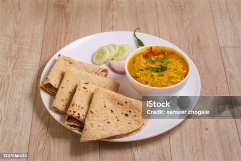 인도 요리 Sev Kadhi Chapati 버터 밀크 세브와 병아리 완두콩 가루로 만든 채식 카레 그릇이나 카라히에서 나무 배경