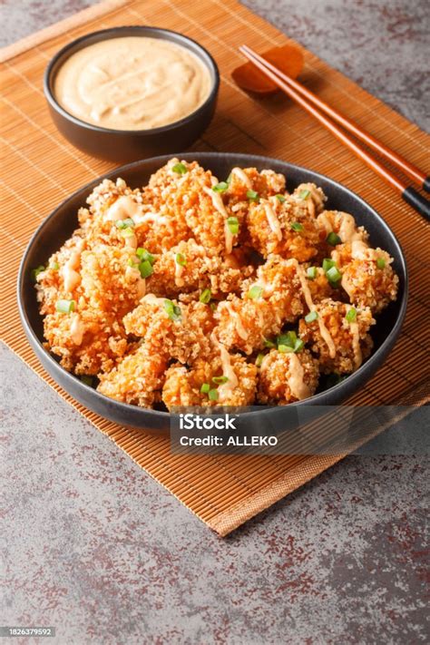 뱅뱅 치킨은 바삭바삭한 판코 크러스트로 코팅된 부드러운 닭고기 덩어리를 황금색으로 튀긴 다음 마지막으로 접시에 크림 같고 달콤하고 매운 소스 클로즈업으로 질식시킨 것입니다