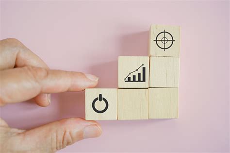 나무 큐브 블록에 손 잡기 시작 버튼 그래프 및 대상 아이콘 목표 개념 비즈니스 전략 새로운 경력 이나 제품을 시작 하 고 단계를 의미 Next Level English