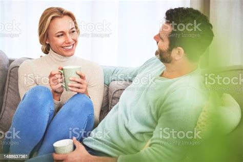 커플 커피 소파 위의 거실에서 행복하고 집에서 유대감과 대화를 나눕니다 차 미소 성숙한 남자와 여자가 휴식을 취하고 이야기하고