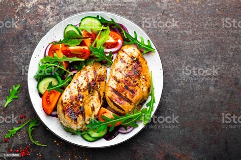 구운 치킨 가슴살 튀긴 치킨 필 레와 토마토 오이 Arugula 잎의 신선한 야채 샐러드 샐러드와 치킨 고기 건강 한 음식