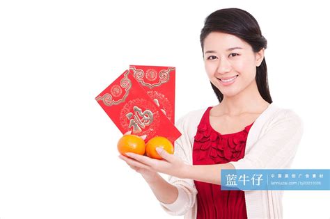 年轻女子手拿红包和桔子 蓝牛仔影像 中国原创广告影像素材