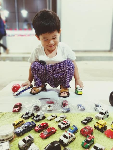 Niño Jugando Con Coches De Juguete En Casa Foto Premium