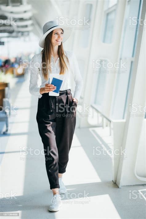 공항 환승 구역에서 여권을 들고 있는 여성 여행자 다음 일정 여행 도착 출발 지연 탑승권 체크인 누락 건네주기에 대한 스톡 사진