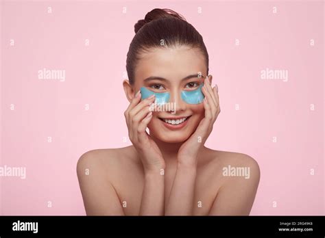 Portrait Of Asian Woman Using Silicone Under Eye Patches And Smiling