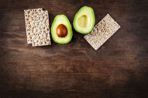 아보카도 과일입니다 싱 싱 Wholegrain와 아보카도의 두 반쪽 빵 갈색 나무 배경에서 조각 Copyspace입니다 상위 뷰