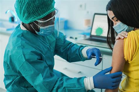 코로나바이러스 질환에 대한 백신을 환자에게 주는 헤이즈마트 정장과 보호 장갑을 가진 의사 의료 및 의료 개념 소녀 얼굴에 초점