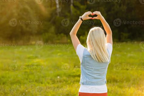 A Young Girl Making Heart Symbol With Her Hands At Sunset 16718548