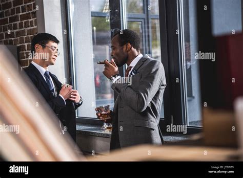 Confident Businessman Drinking Alcohol Beverage And Smoking Cigar While
