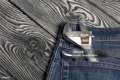 청바지 의 뒷 주머니에서 렌치와 렌치가 튀어나와 조절 가능한 렌치 그들은 검은 색 기모 소나무 보드에 누워 노동절의 상징 강철에 대한 스톡 사진 및 기타 이미지 Istock