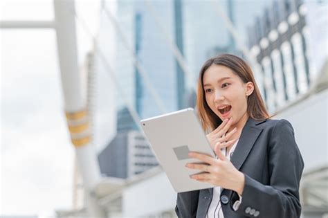 매력적인 젊은 아시아 전문 사업가 숙녀 그녀의 얼굴에 좋은 미소를 가진 그녀의 얼굴에 마케팅 및 판매 재고 보고서의 최신 업데이 트를보고 방콕 도시의 중앙 비즈니스 지구에