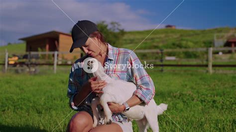 Young Woman Stroking A Young White Boer Goat On The Farm Country Girl