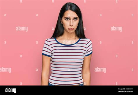 Young Hispanic Girl Wearing Casual Striped T Shirt Depressed And Worry