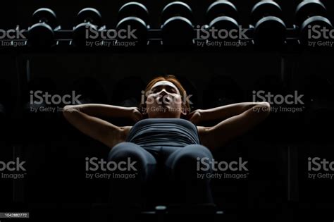 아시아 스포츠 여자 하 고 앉아 어둠 속에서 체육관 운동에서 피트 니스 스튜디오에서 아령 선반에 어린 소녀 훈련 복 부