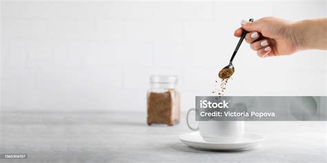 한 여성이 회색 돌 테이블에 흰 찻잔에 인스턴트 커피를 추가합니다 공간을 복사합니다 가루로 빻은에 대한 스톡 사진 및 기타 이미지 가루로 빻은 마실 것 따르기