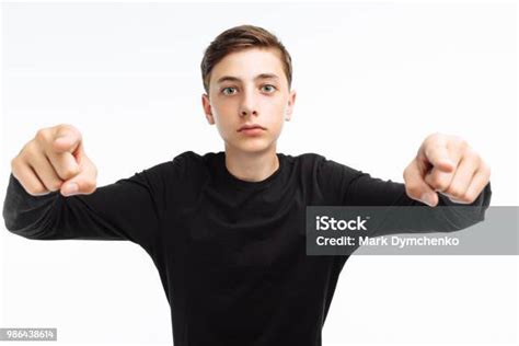 아름 다운 십 대 놀란된 표정으로 한 남자의 초상화 블랙 T셔츠 흰색 배경에 광고 텍스트 삽입 카메라에 그의 손을 포인트합니다 T 셔츠에 대한 스톡 사진 및 기타 이미지