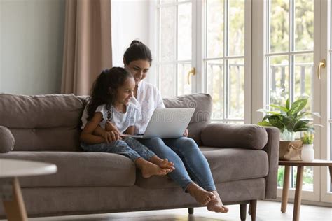 Loving Indian Mother And Little Daughter Spend Leisure Using Laptop