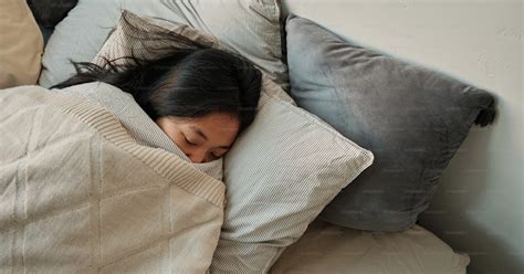 담요와 베개를 베고 침대에서 자고 있는 여자 사진 Unsplash의 편안한 이미지