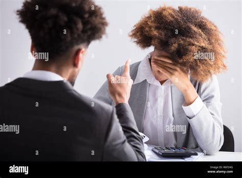 Businessman Pointing At His Female Employee Stock Photo Alamy