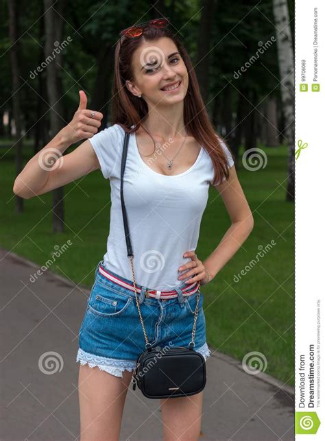 La Muchacha Hermosa Flaca Joven Se Coloca En El Parque Y La Sonrisa Imagen De Archivo Imagen