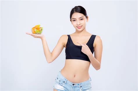 아름 다운 초상화 젊은 아시아 여자 들고 웃는 흰색 배경에 고립 된 샐러드 야채 식품 건강 한 건강 관리 또는 웰빙 개념에 대 한 채식주의자를 먹는 여자 다이어트 가냘픈에
