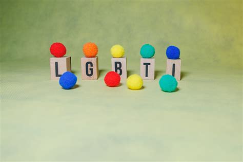 노란색 배경의 다양한 색상의 공으로 장식된 나무 글자가 있는 Lgbti 단어 0명에 대한 스톡 사진 및 기타 이미지 0명