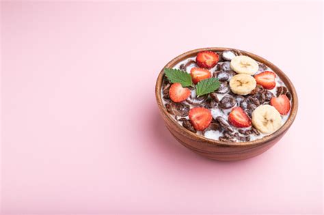 분홍색 파스텔 배경에 나무 그릇에 우유와 딸기 초콜릿 콘플레이크 측면 보기 복사 공간 0명에 대한 스톡 사진 및 기타 이미지