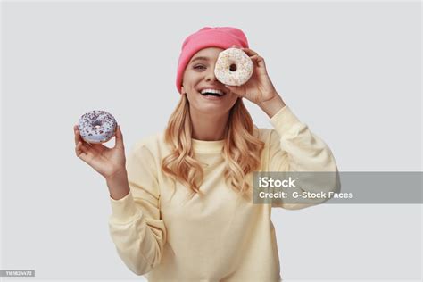 회색 배경에 서있는 동안 도넛과 미소로 눈을 덮고 매력적인 젊은 여성 스튜디오 촬영에 대한 스톡 사진 및 기타 이미지 스튜디오 촬영 여자 한 명의 여자만 Istock