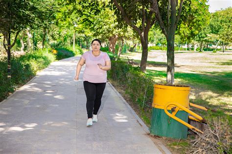 여름 공원에서 야외에서 달리는 아름다운 과체중 인도 여성 뚱뚱한 아가씨 조깅 플러스 사이즈 피트니스 라이프 스타일 체중 감량 전체 길이 샷 플러스 사이즈 모델에 대한 스톡
