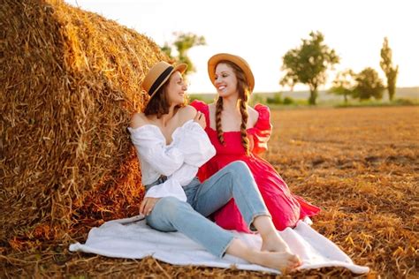 Dos mujeres jóvenes divirtiéndose cerca del pajar concepto de moda