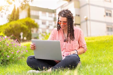 Photo Of European Woman 25s Sitting On Green Grass In Park With Legs