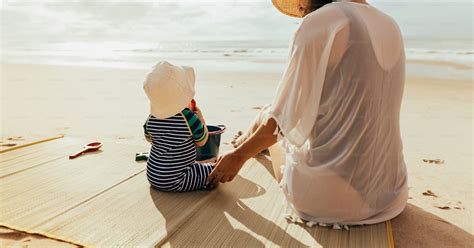여름 방학 동안 해변에서 놀고 있는 어머니와 어린 아들 사진 Unsplash의 성인 이미지