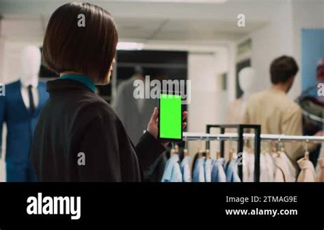 Young Assistant Using Blank Greenscreen Template Showing Chroma Key Display In Trendy Clothing