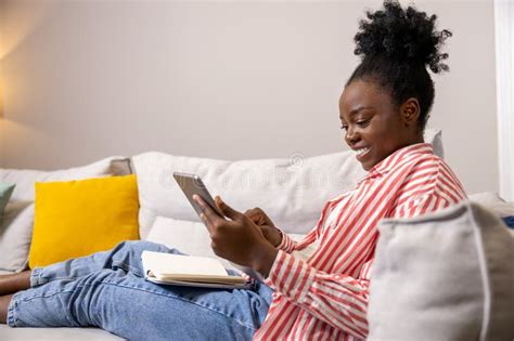 Optimistic Woman Relaxing On Sofa Using Digital Tablet Scrolling Online