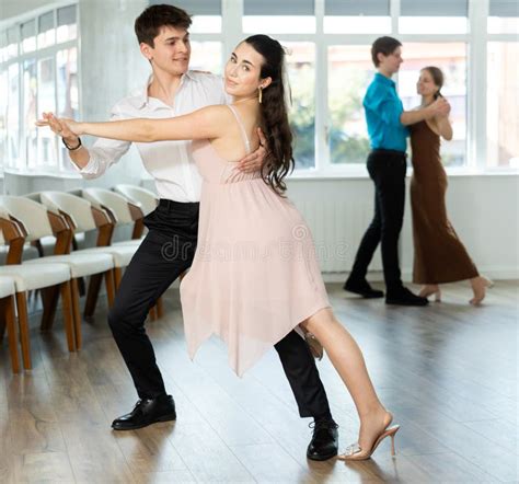 Couple In Evening Dresses Enjoys Pair Dance Tango Interacting With Each Other On Floor Stock