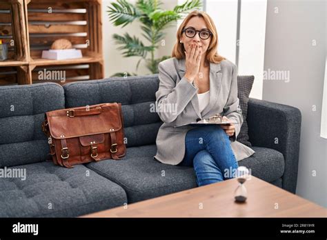 Hispanic Woman Working At Consultation Office Laughing And Embarrassed